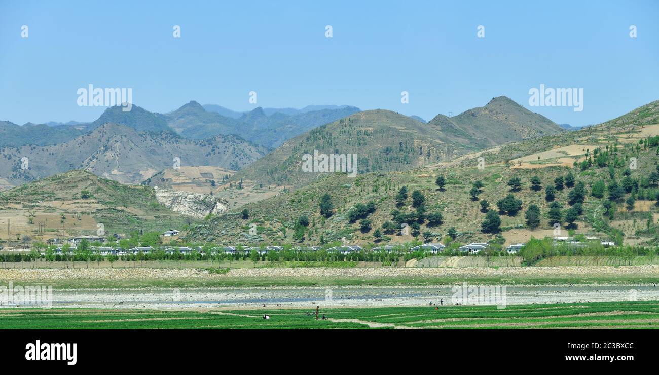North Korea landscape. Mountains, village and plowed agriculture fields ...