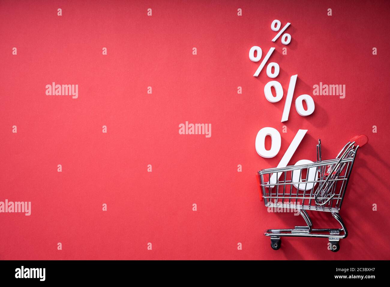 Sale Percents Falling Into Shopping Cart On Red Background Stock Photo ...