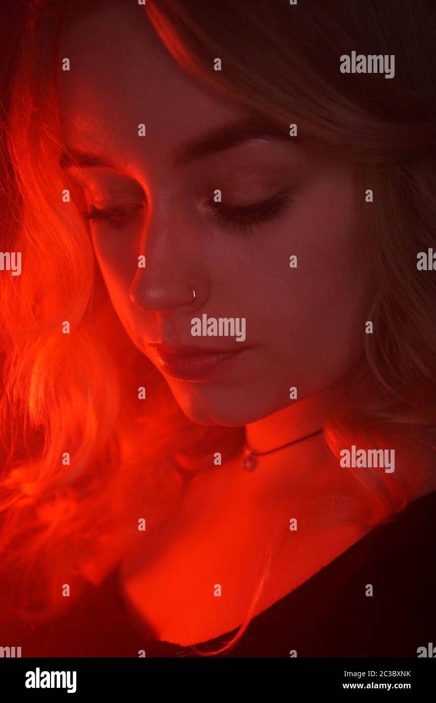 Warm red light with blond curly woman Stock Photo - Alamy