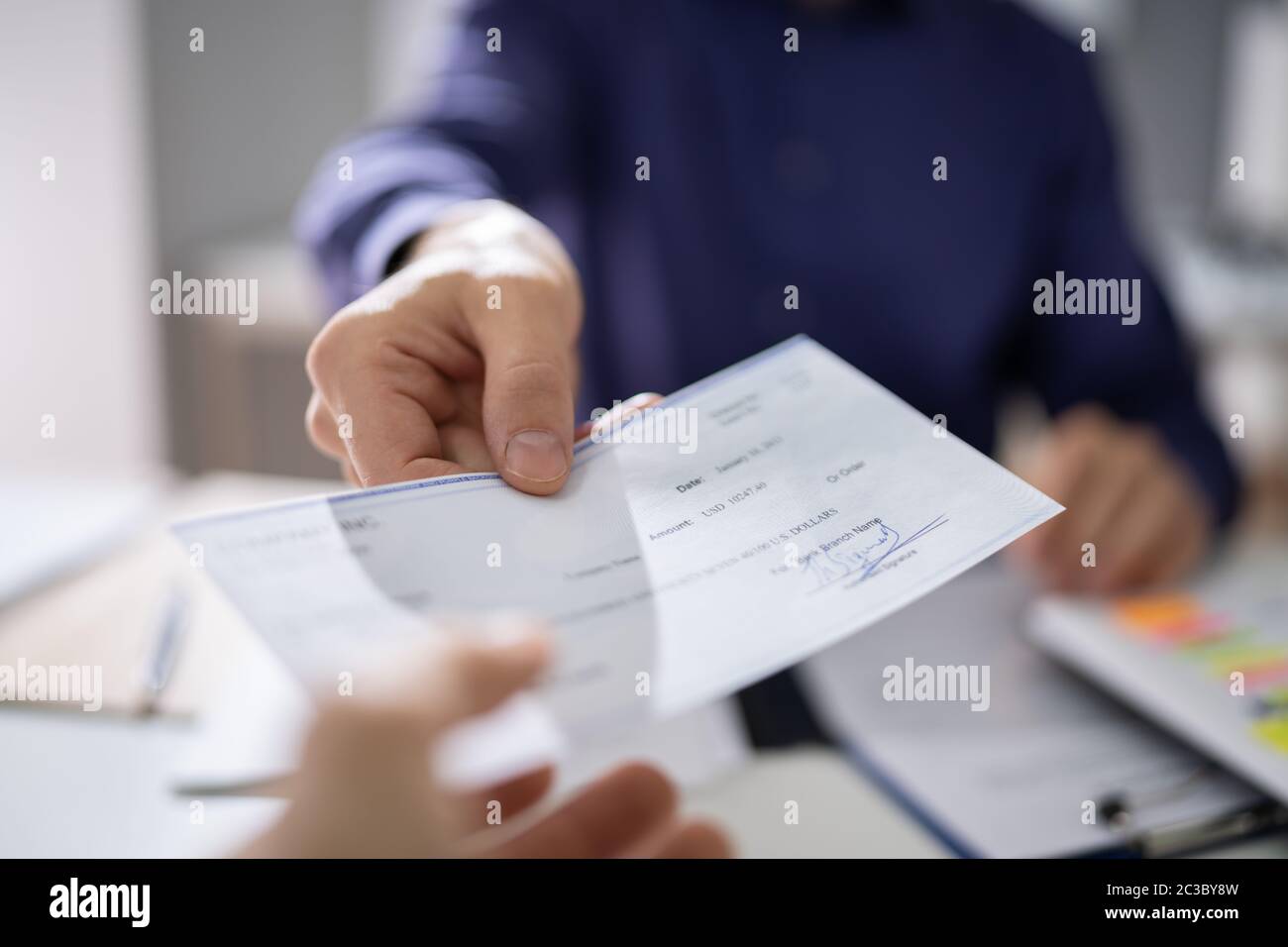 Businessperson Hands Giving Cheque To Other Person Stock Photo - Alamy
