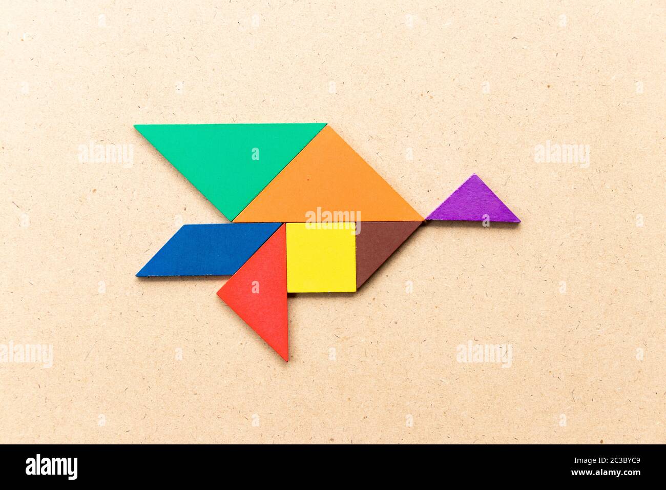 Color tangram puzzle in flying bird shape on wood background Stock ...