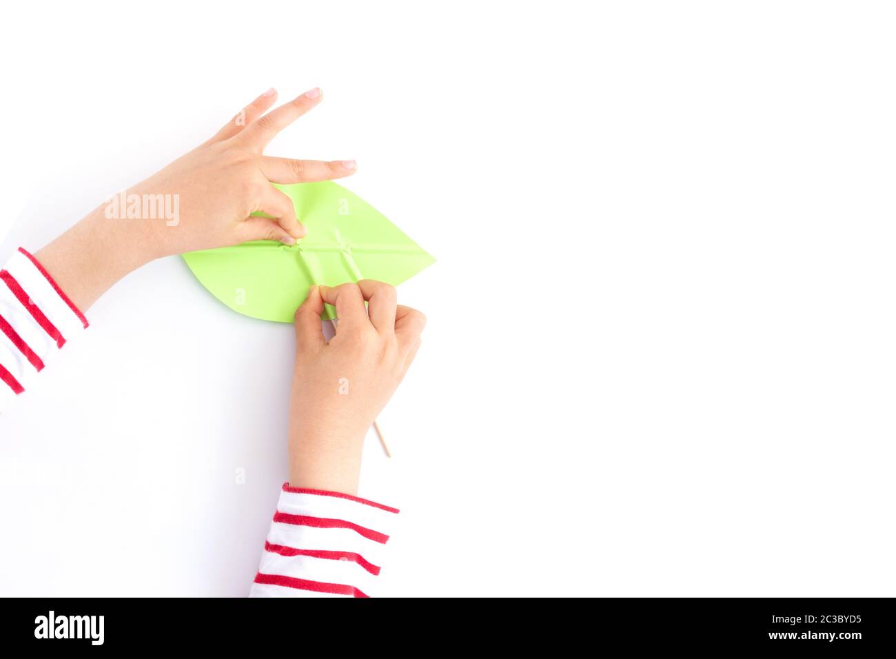 kids hands push strips on a green leaf shape paper detail, simple paper ...