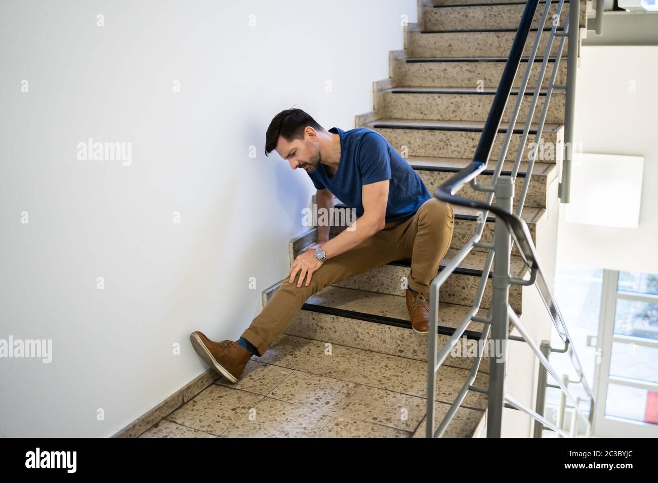 Man Sitting On Staircase After Slip And Fall Accident Stock Photo - Alamy
