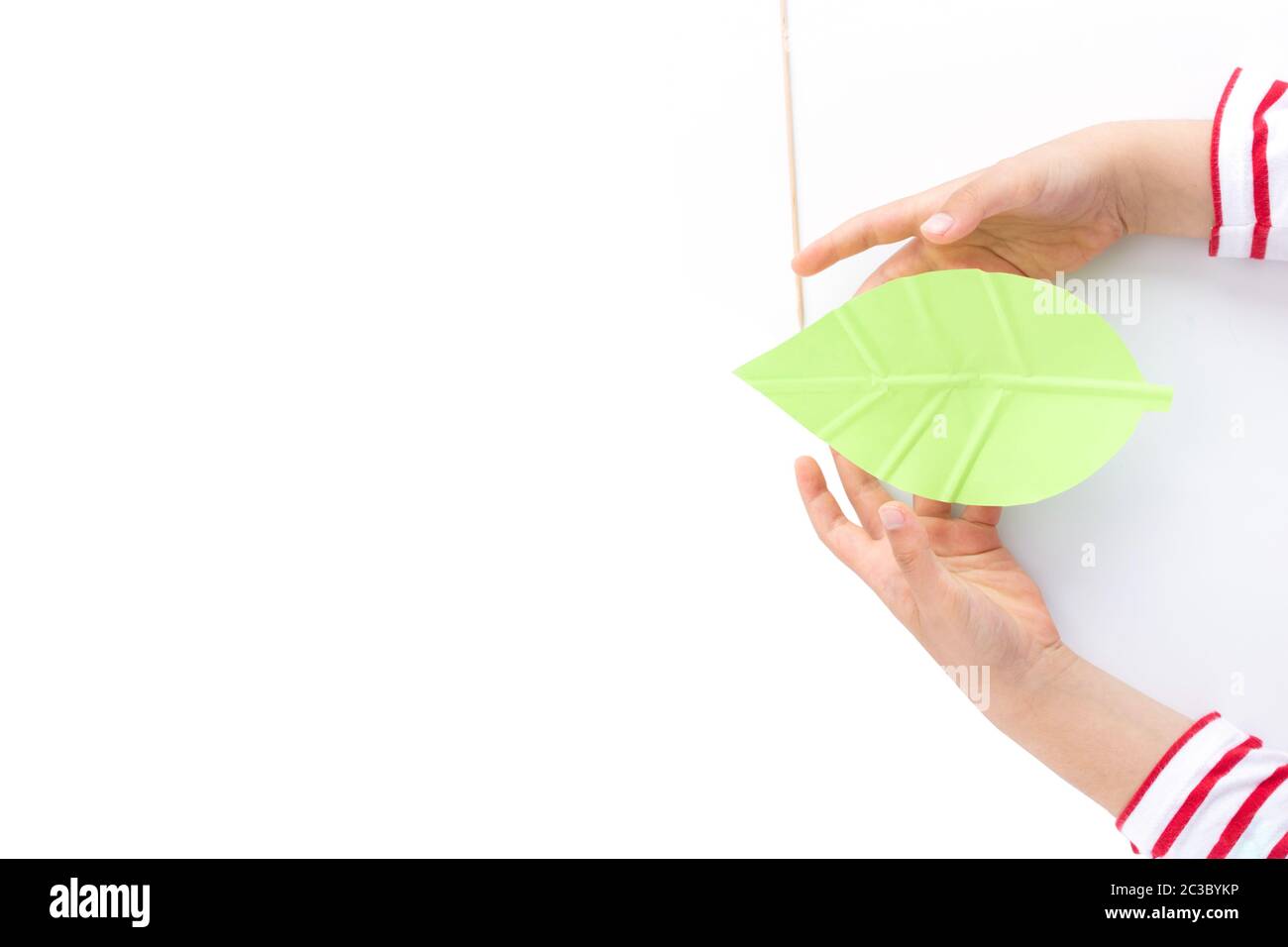 kids hands push strips on a green leaf shape paper detail, simple paper ...