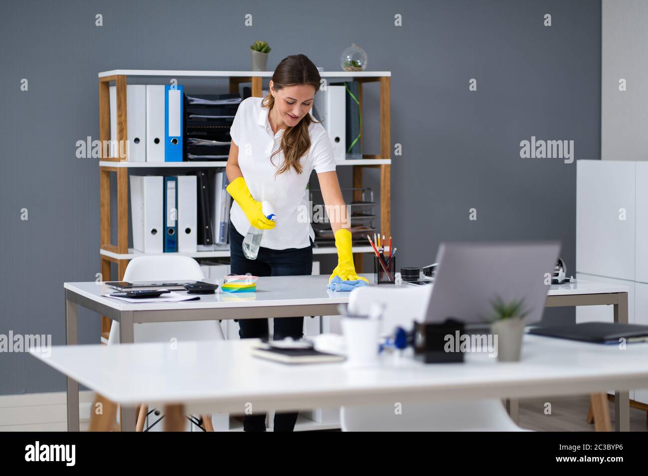 Young Worker Cleaning Desk With Rag In Office Stock Photo - Alamy