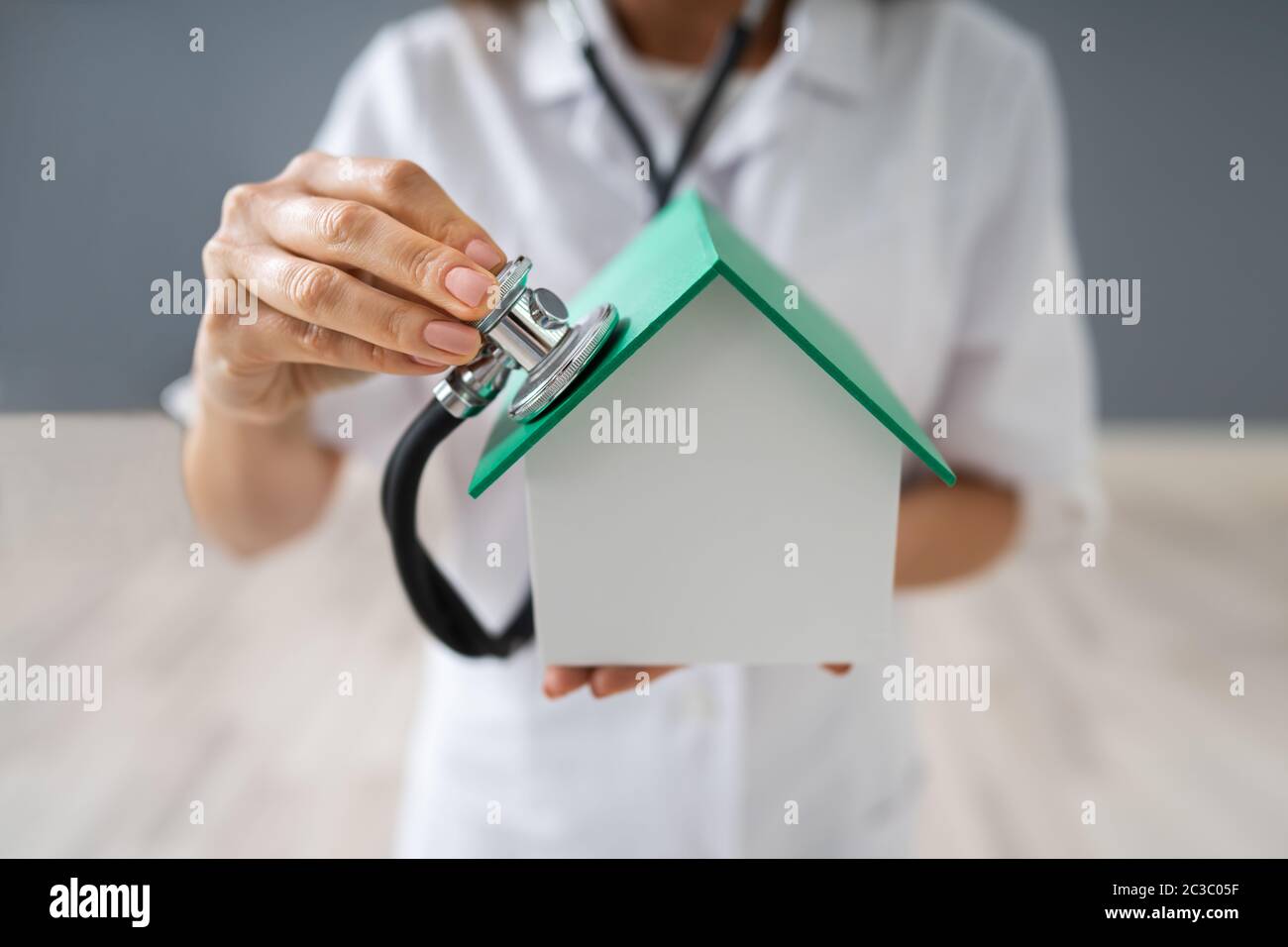 Close-up Of A Doctor's Hand Holding Stethoscope On House Model Stock ...