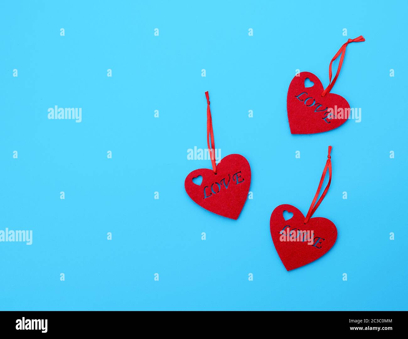 three empty felt red hearts on a blue background. Holiday celebration ...