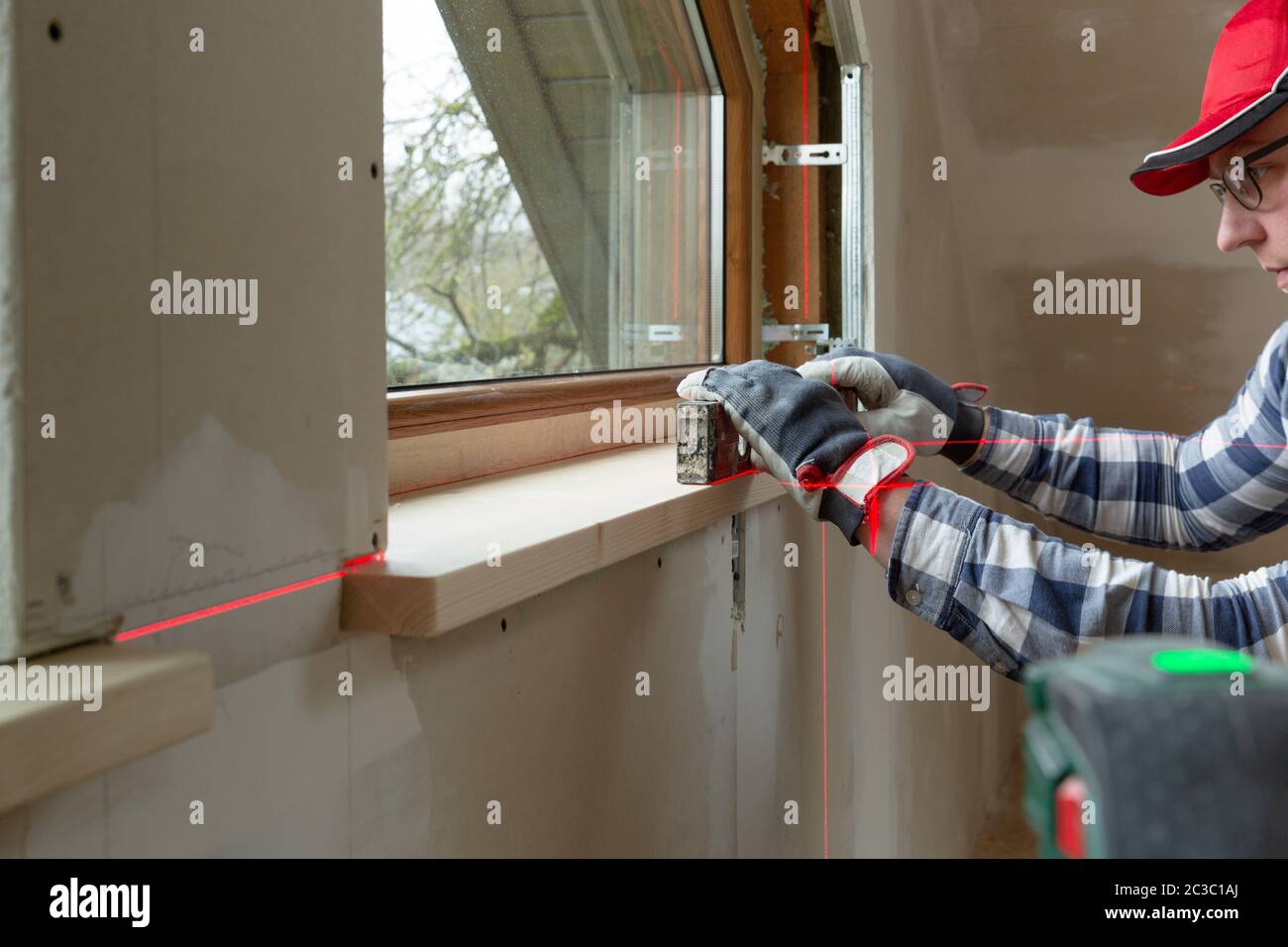 home improvement handyman installing window sill in new build attic by ...
