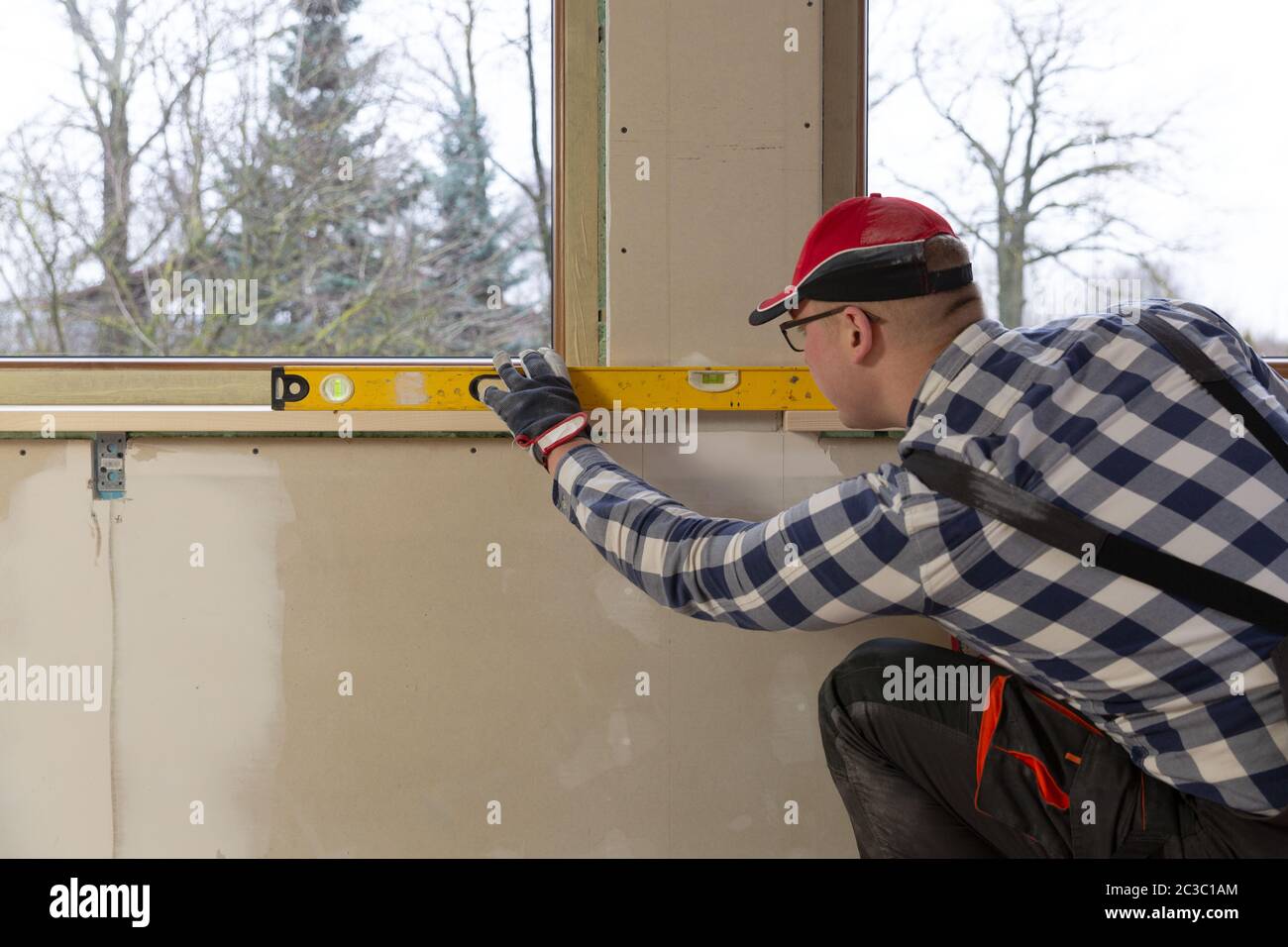 home improvement handyman installing window sill in new build attic by ...