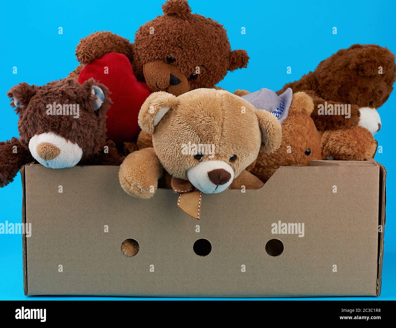 brown cardboard box with various teddy bears, blue background, concept ...
