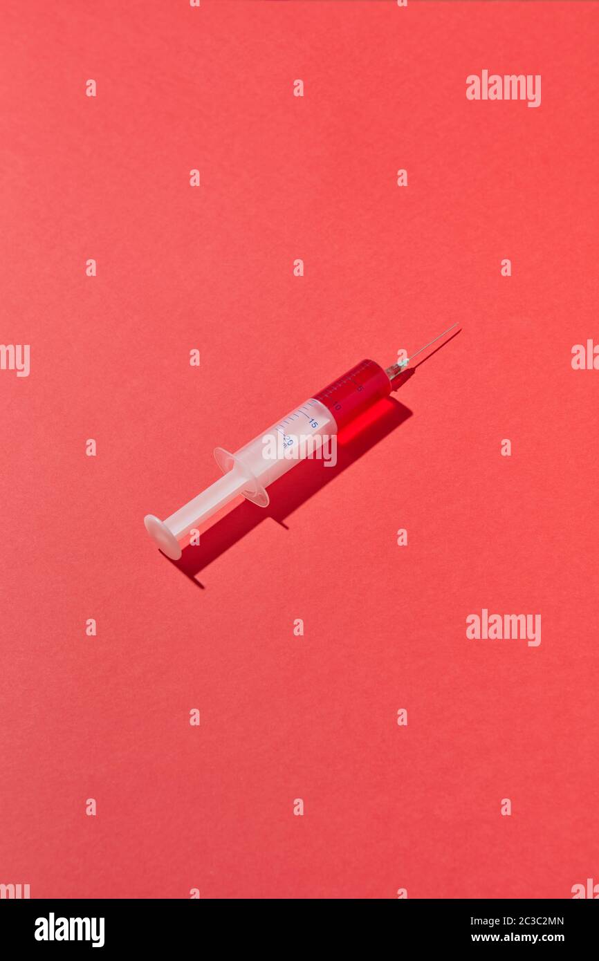Disposable syringes of red blood or vaccine with shadows Stock Photo ...