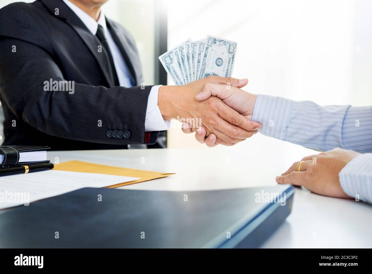 Businessman or politician taking bribe and Shaking Hands With Money in ...
