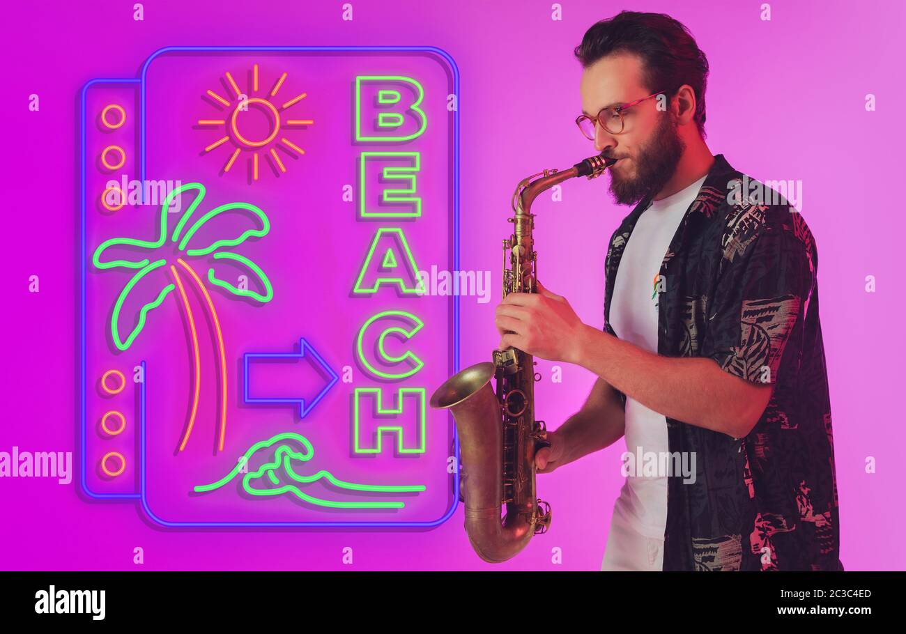 Young jazz musician playing the saxophone on gradient studio background ...