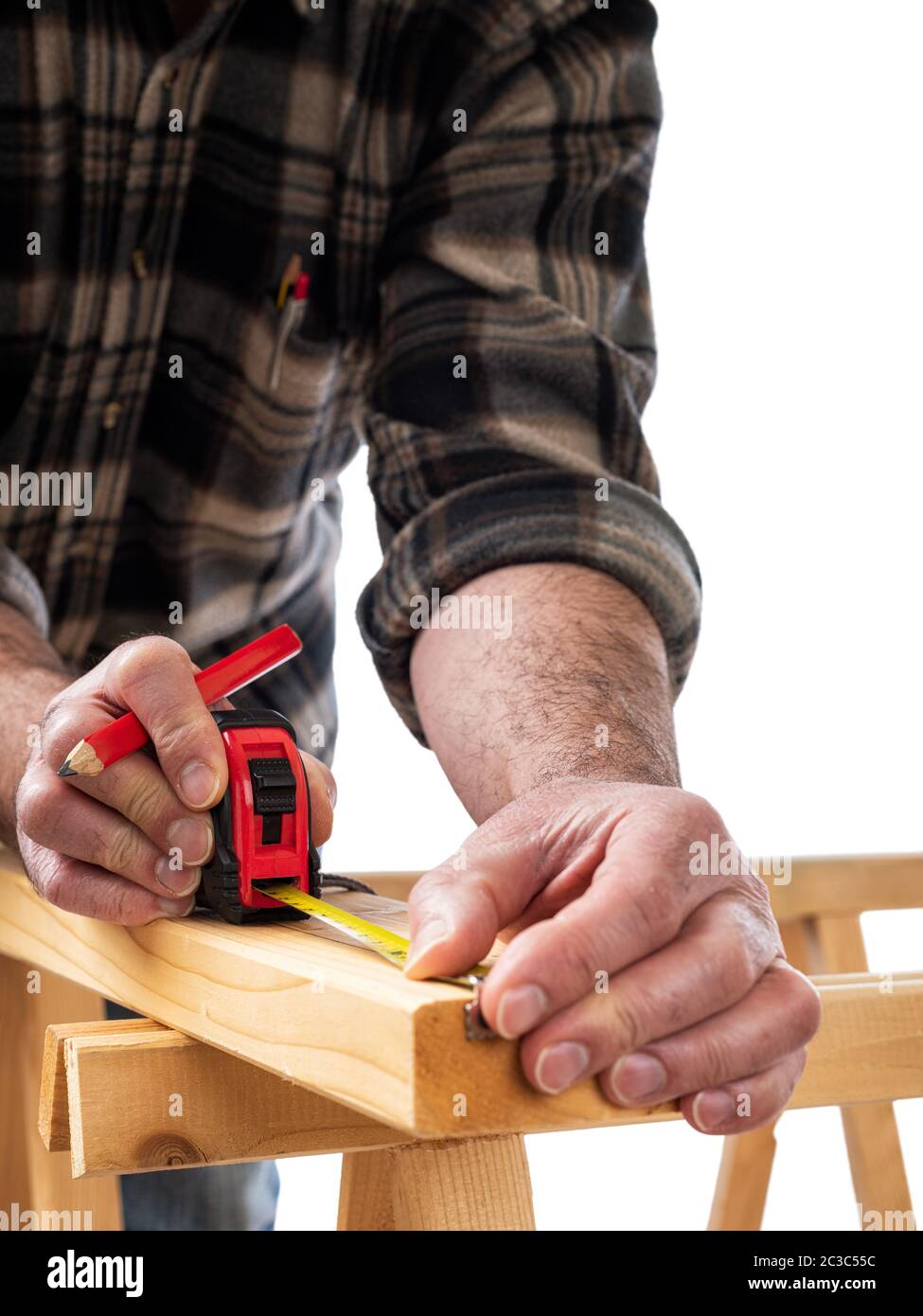 Close-up. Carpenter with pencil and the meter marks the measurement on ...