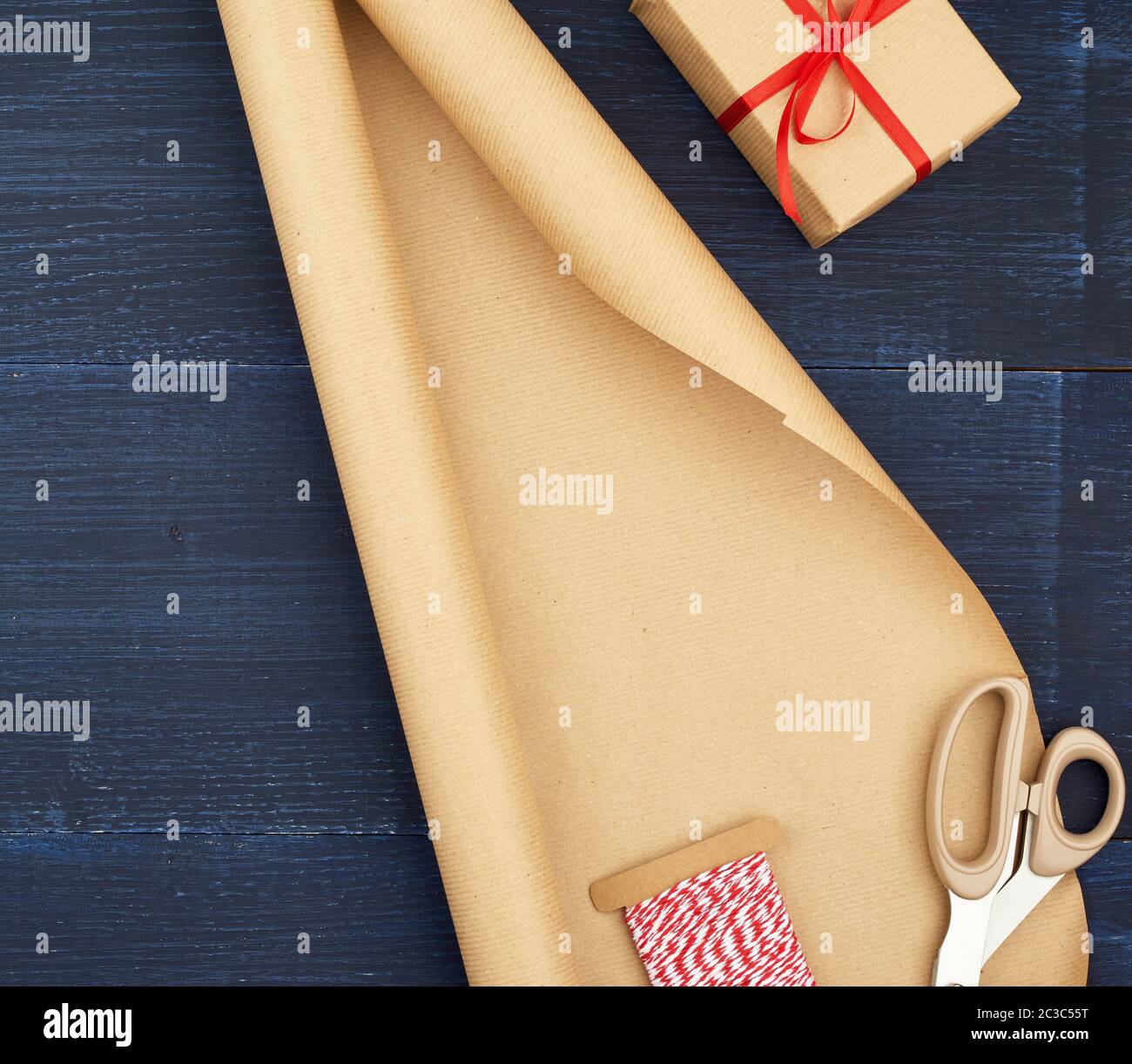 brown kraft paper, packed gift box and tied with a red ribbon, red ...