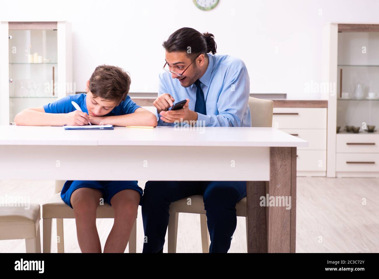 Busy father helping his son to prepare for exam Stock Photo - Alamy