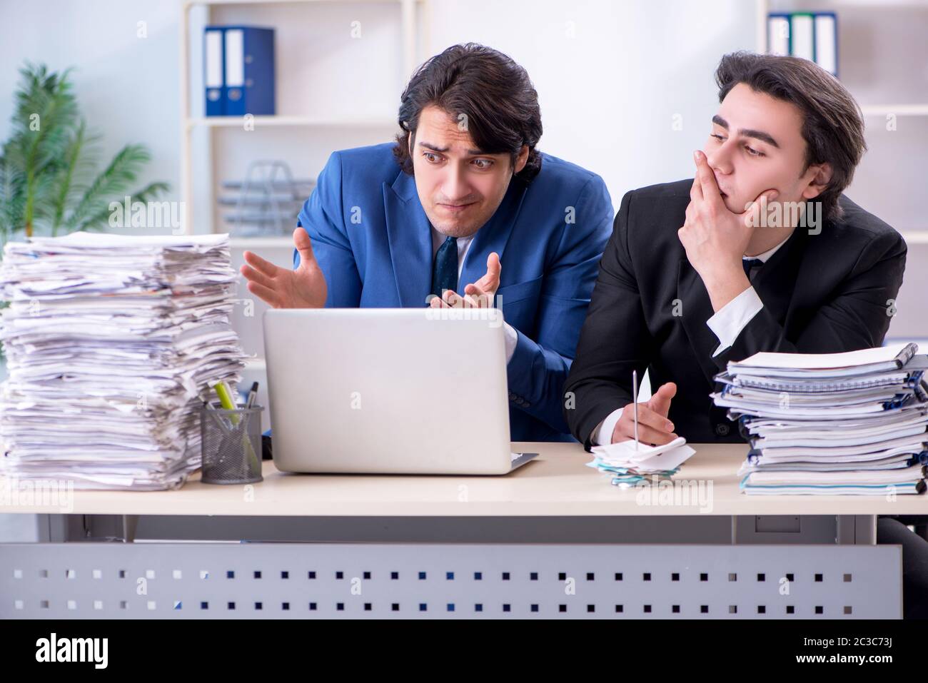 Two male colleagues unhappy with excessive work Stock Photo - Alamy