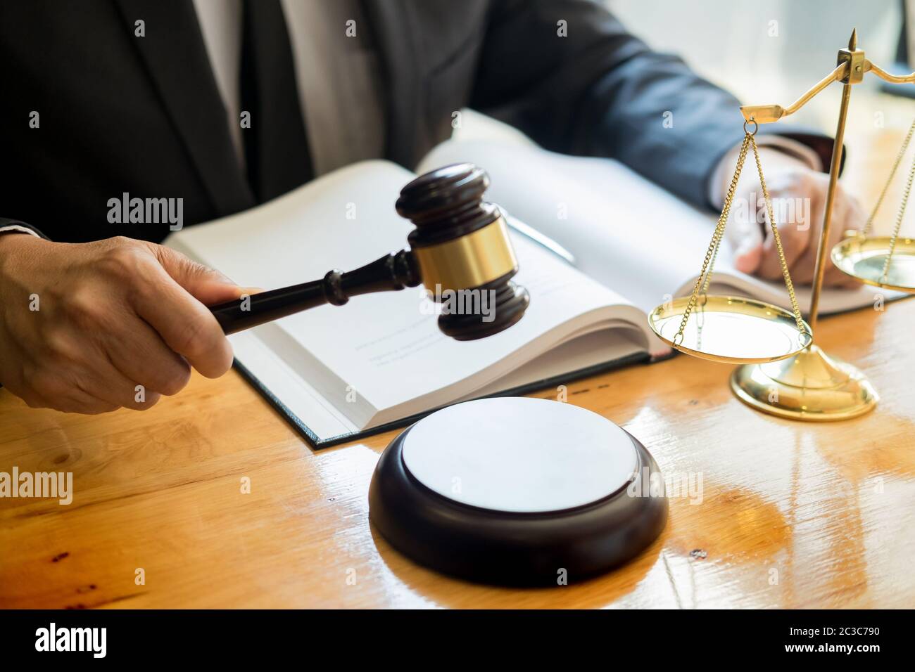 Male lawyer working with contract papers and reading law book in a ...