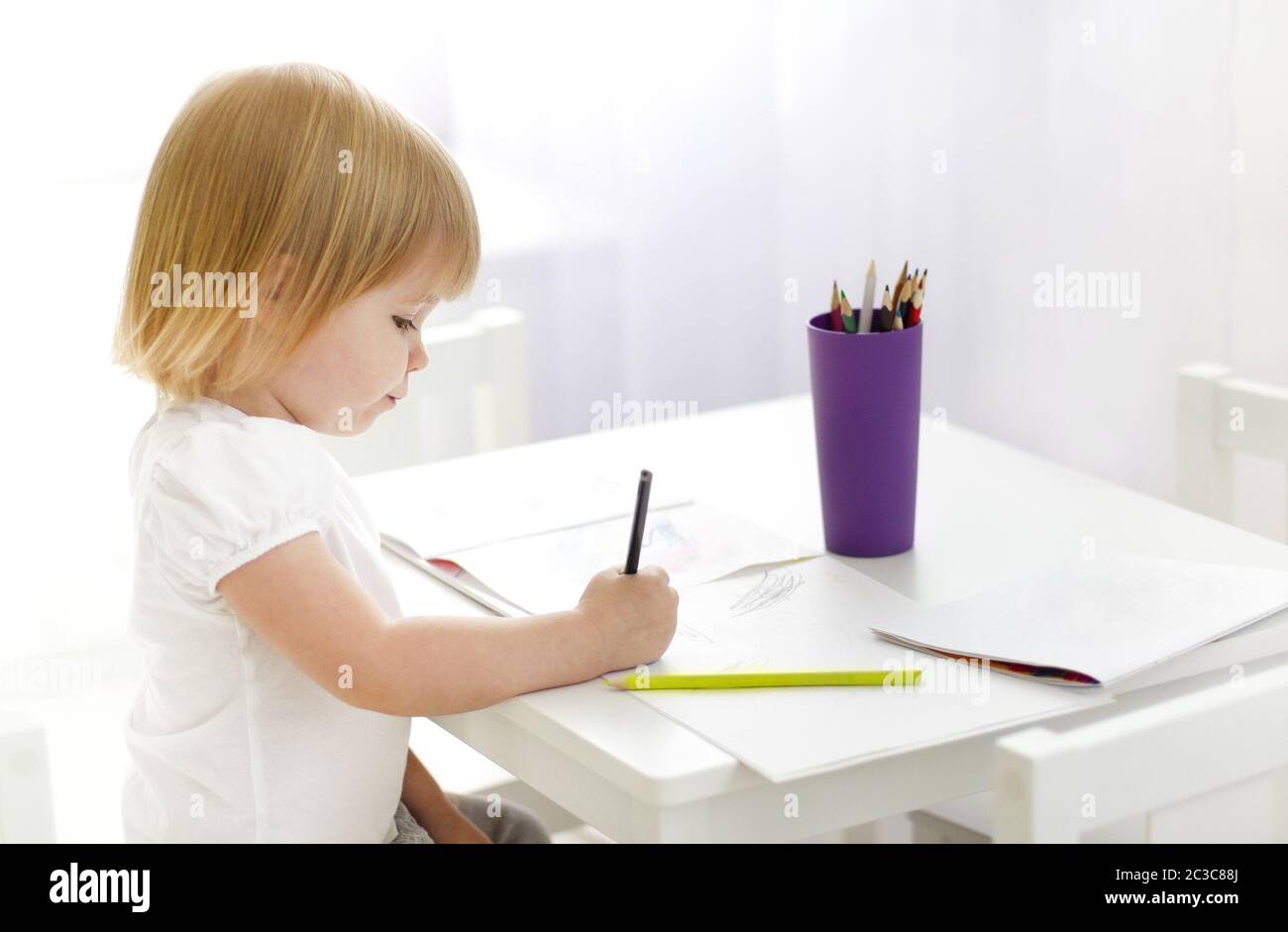 Smart cute girl drawing with pencil at home Stock Photo - Alamy