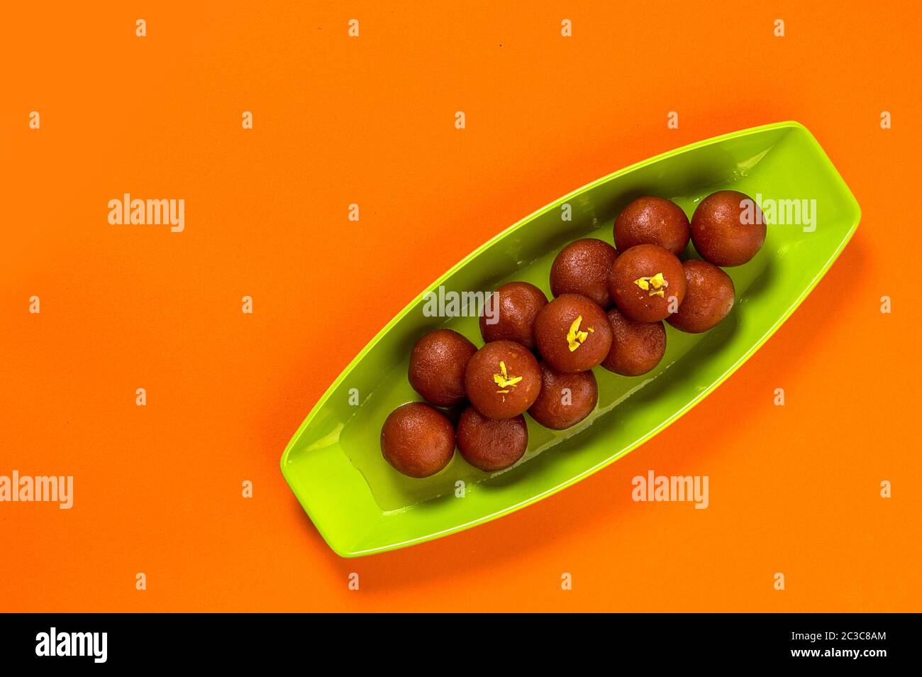 Indian Dessert Gulab Jamun in plate on orange background Stock Photo ...