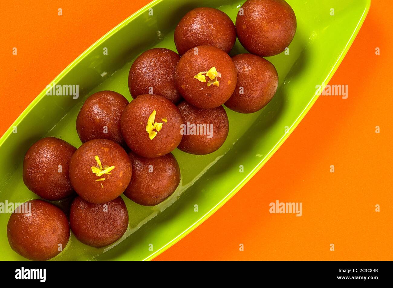Indian Dessert Gulab Jamun in plate on orange background Stock Photo ...