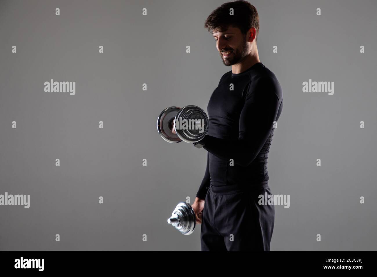 happy young man lifting dumbbells on white background Stock Photo - Alamy