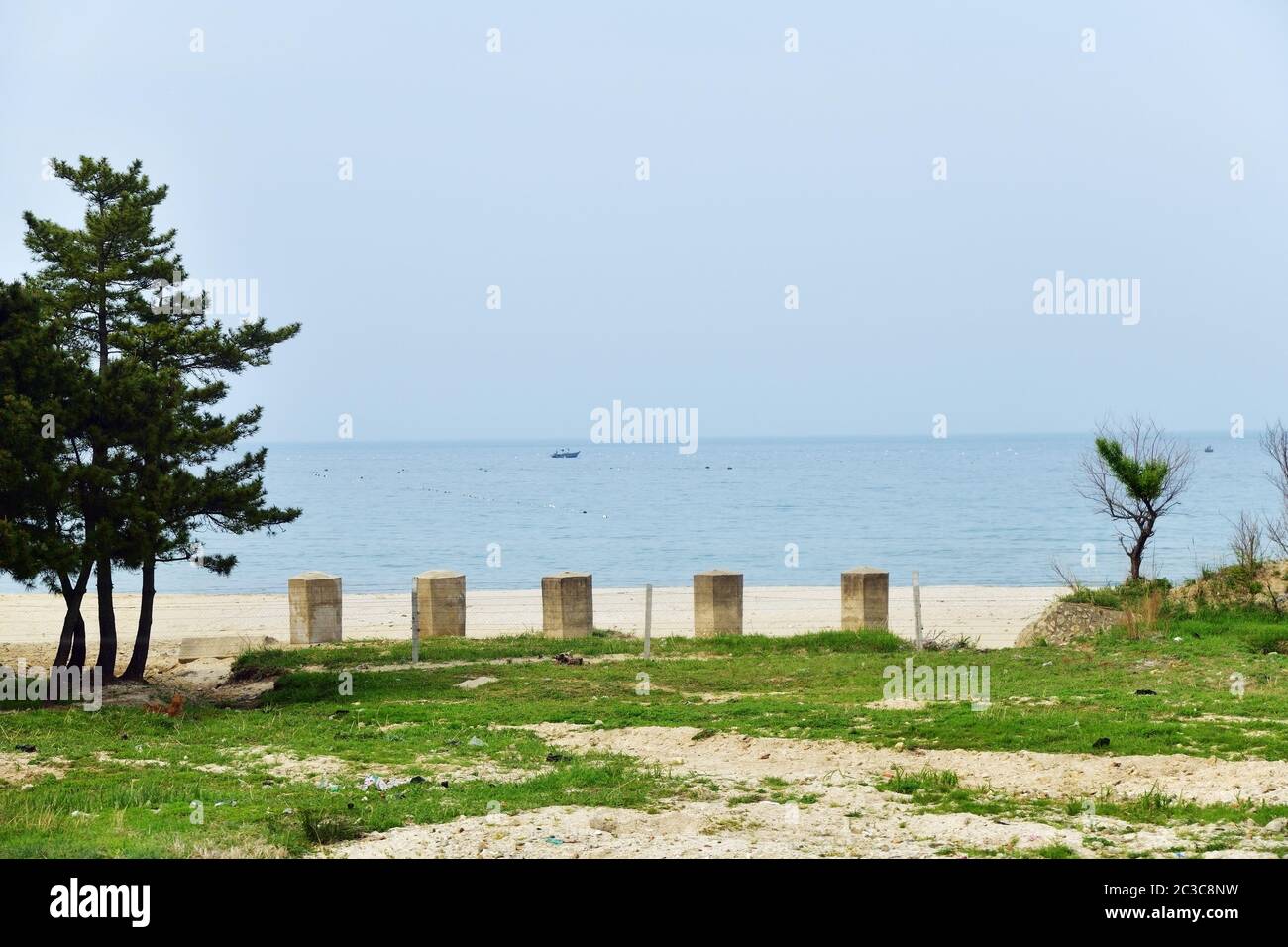 The sand beach and defence system. Barbed wire fence and concrete ...