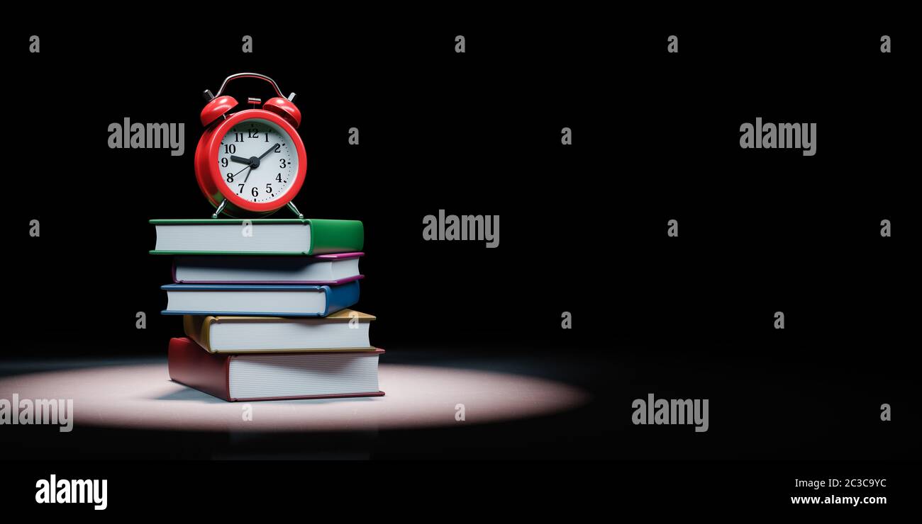 Stack of Books with Alarm Clock Spotlighted on Black Background with ...
