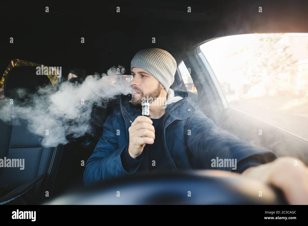 Vaping flavored e-liquid from an electronic cigarette in a car Stock ...