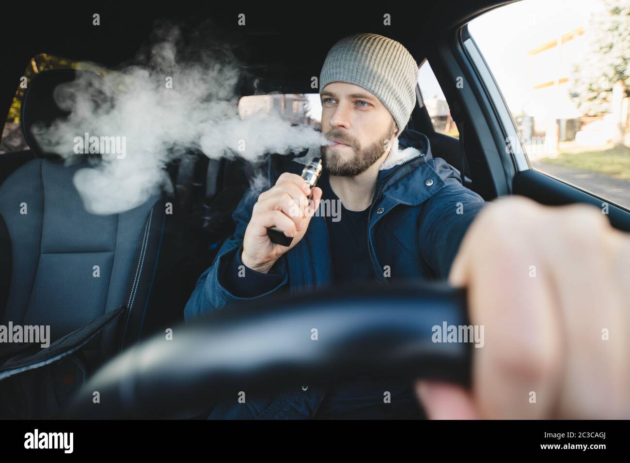 Vaping flavored e-liquid from an electronic cigarette in a car Stock ...