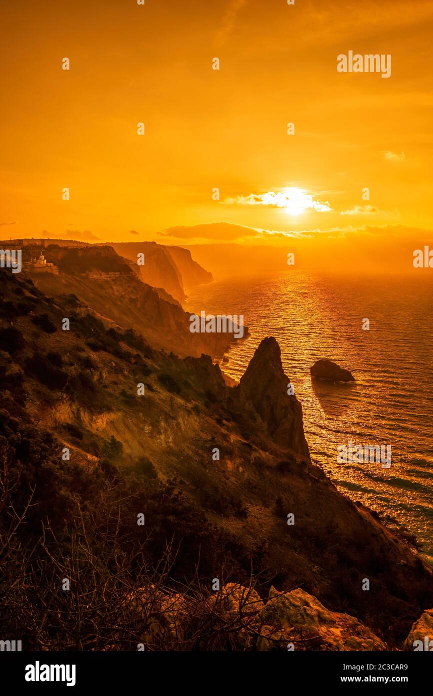 view of the sunset sea and the beach, the volcanic rock, sand and ...