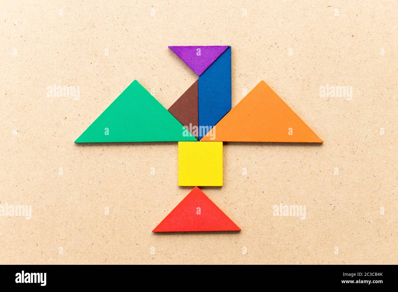 Color tangram puzzle in flying bird shape on wood background Stock ...