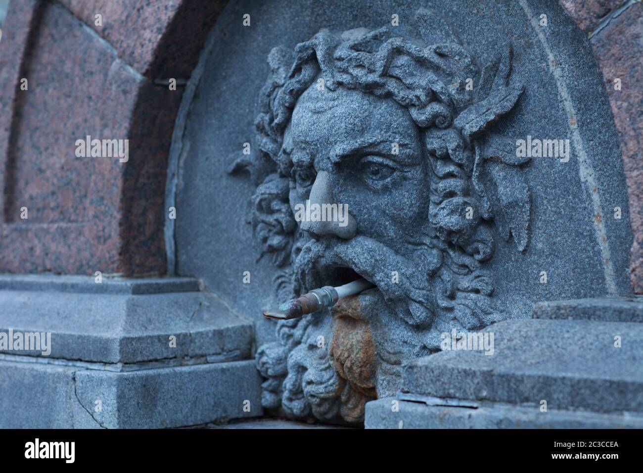 medieval street drinking fountain with stone human head Stock Photo - Alamy