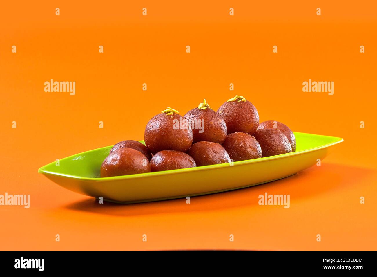 Indian Dessert Gulab Jamun in plate on orange background Stock Photo ...