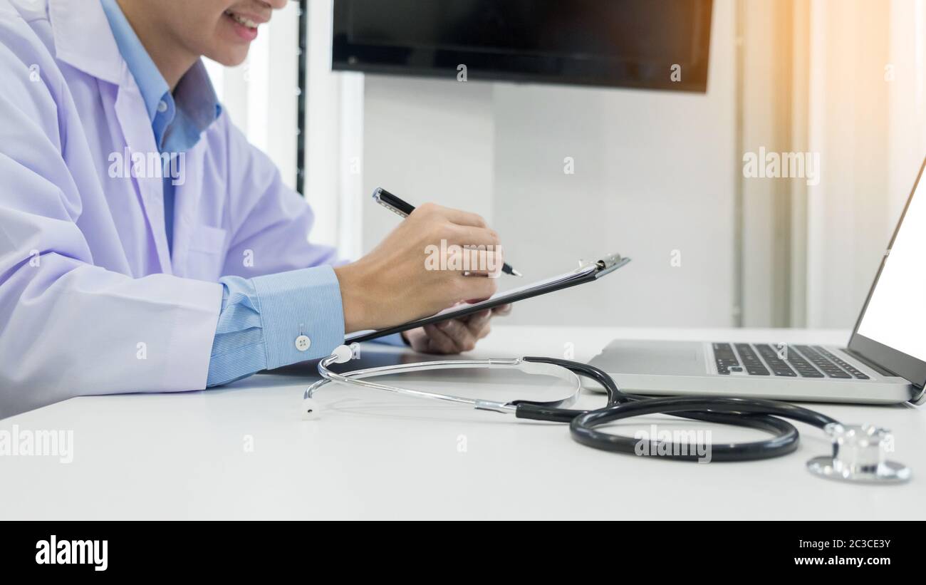 Doctor's hand working using pen writing fills out on patients' medical ...