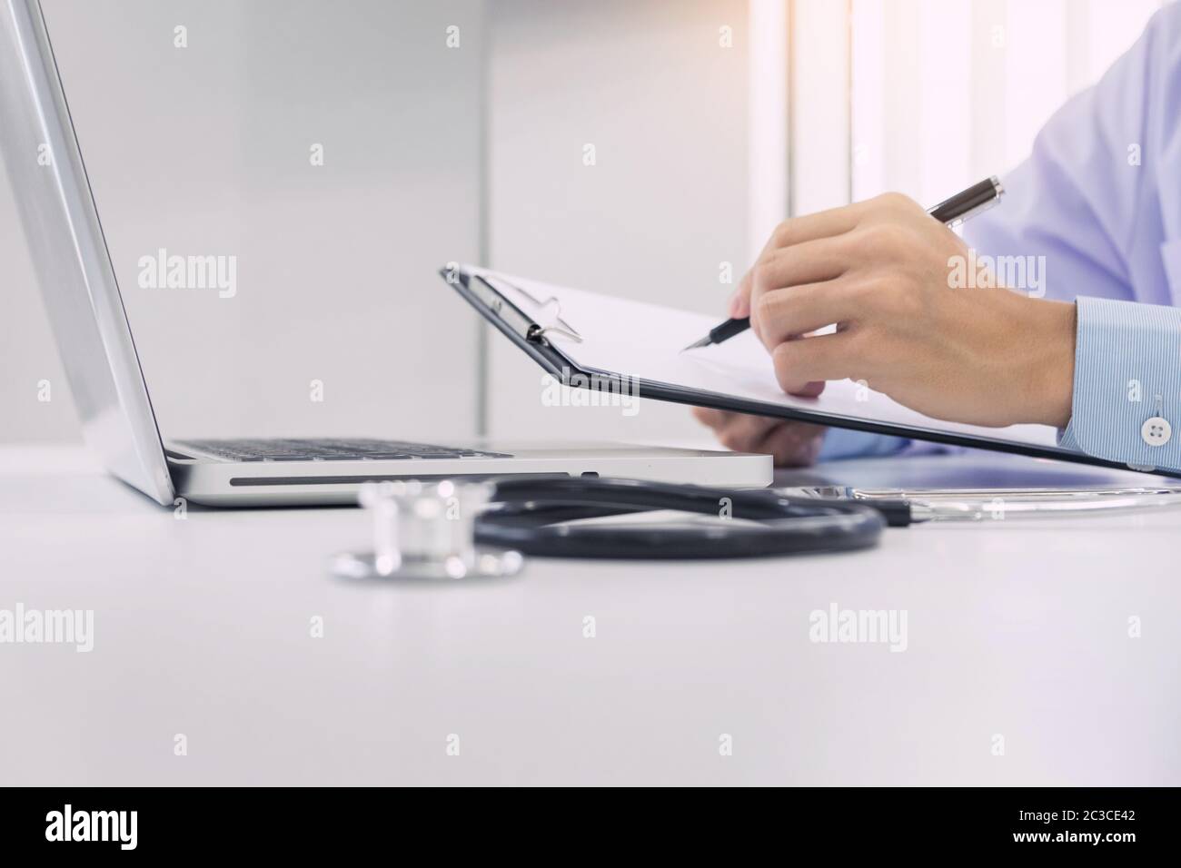 Doctor's hand working using pen writing fills out on patients' medical ...