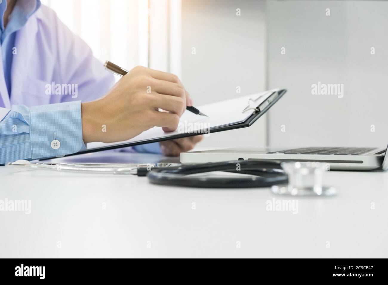 Doctor's hand working using pen writing fills out on patients' medical ...