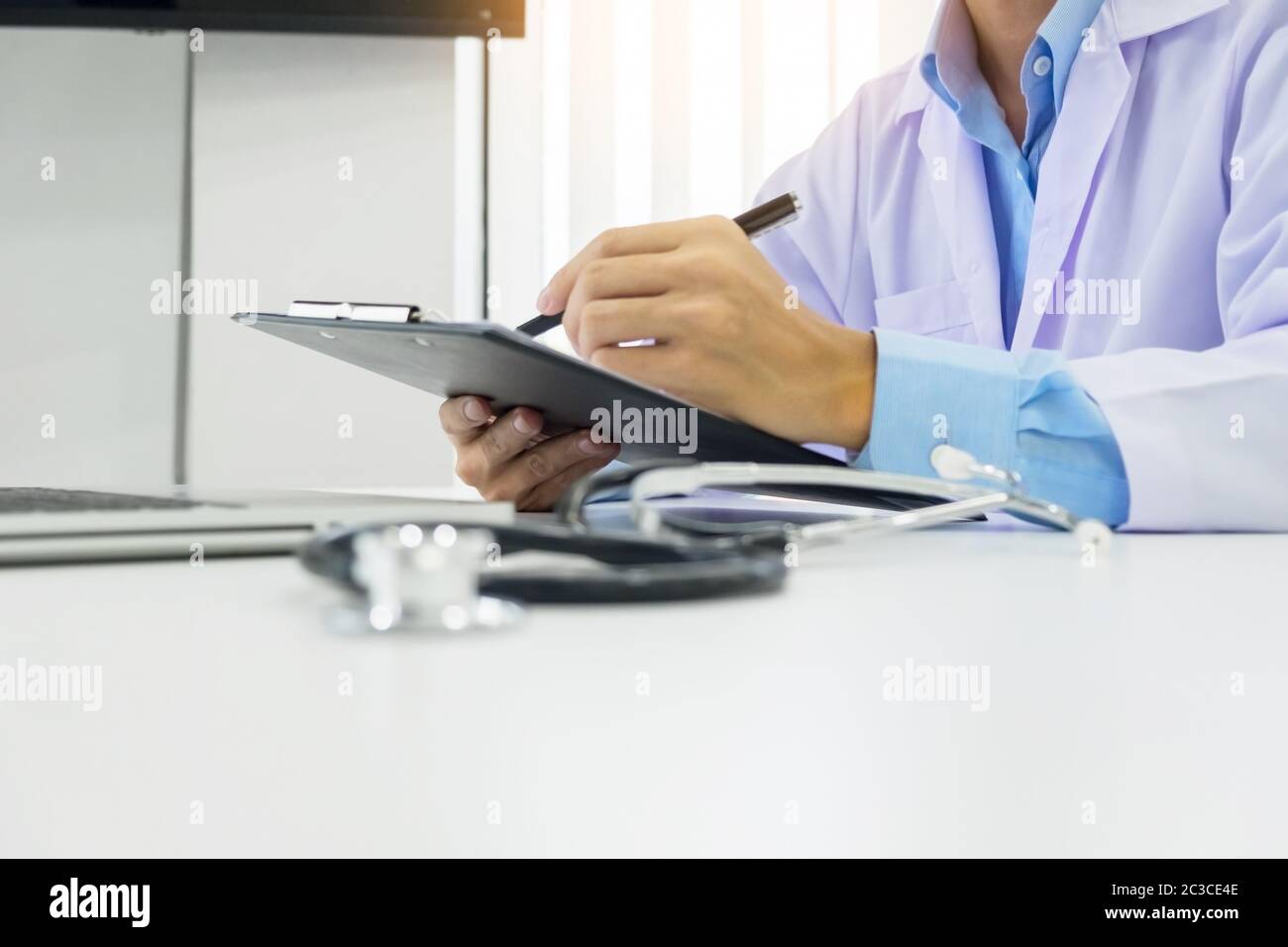 Doctor's hand working using pen writing fills out on patients' medical ...