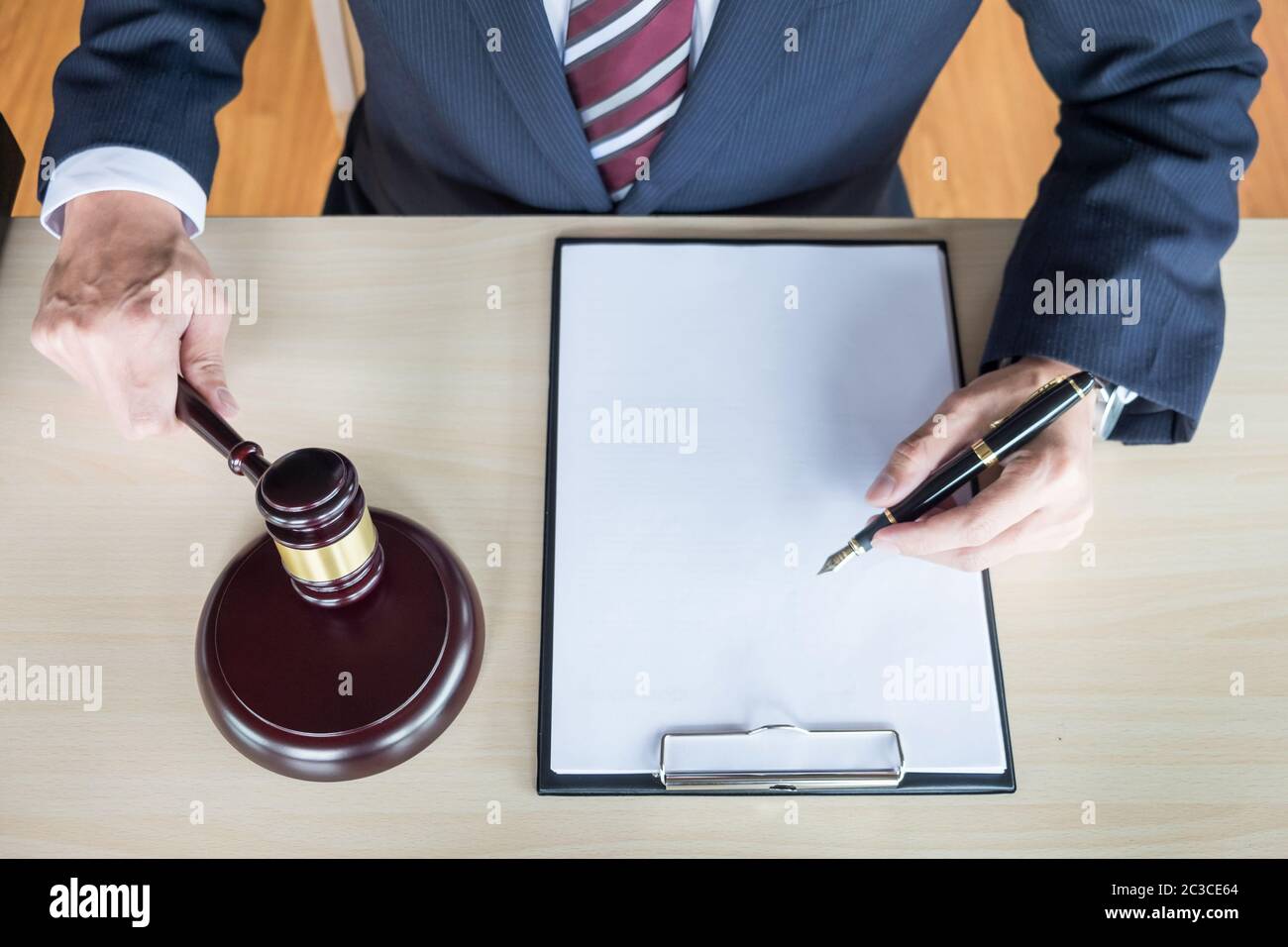 Male Judge In A Courtroom Striking The Gavel on sounding block Stock ...