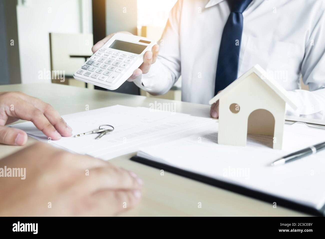 Real estate agent showing the purchase price on a calculator to his ...