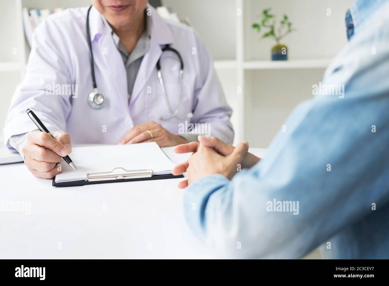 patient listening intently to a male doctor explaining patient symptoms ...