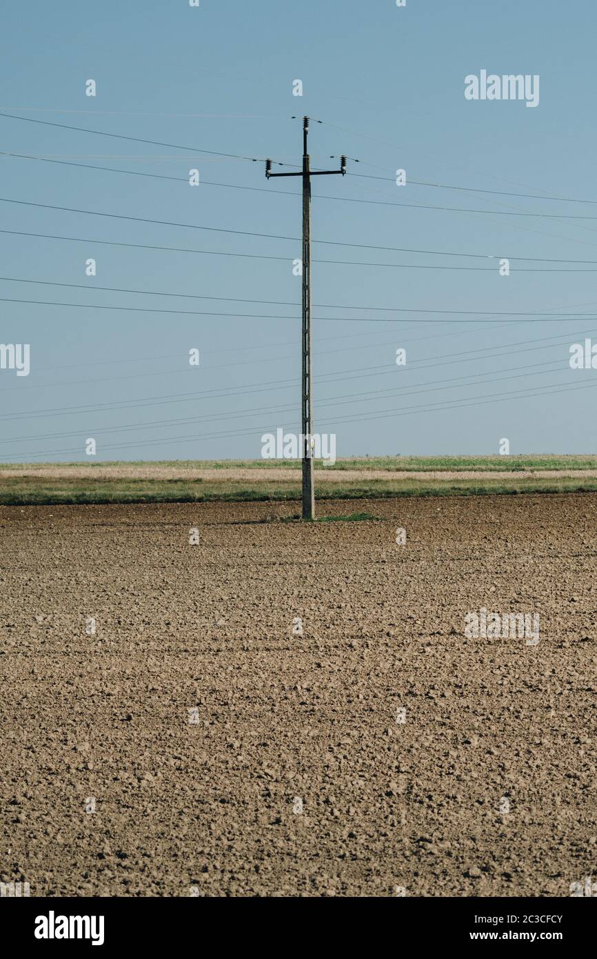 rural landscape with empty fields and power lines at the end of the ...