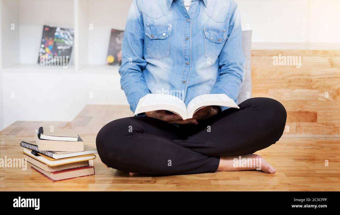 Thoughtful female student sitting Serious reading a book in a library ...