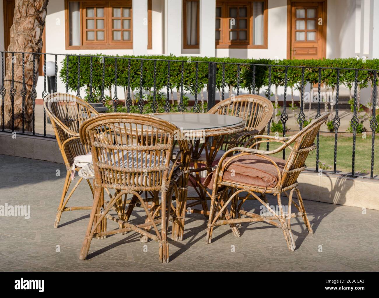 wooden rotan chairs and a round table on the background of the resort ...