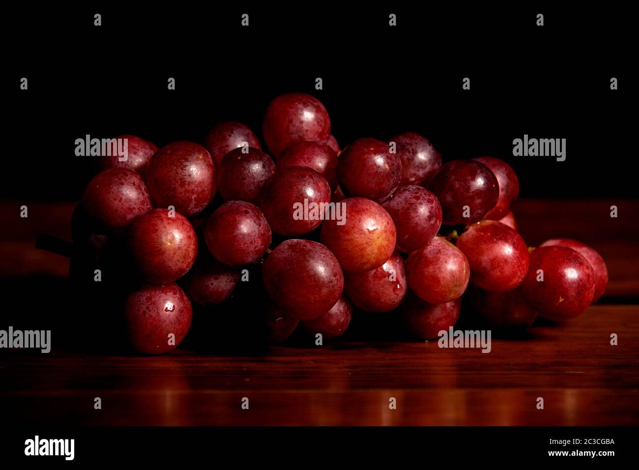 Grapes on wooden table, studio picture Stock Photo - Alamy