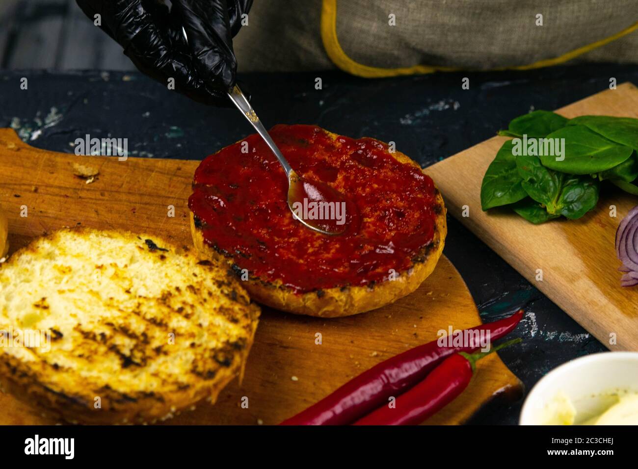 Process of cooking burgers. Cropeed view of chef hands in black gloves ...