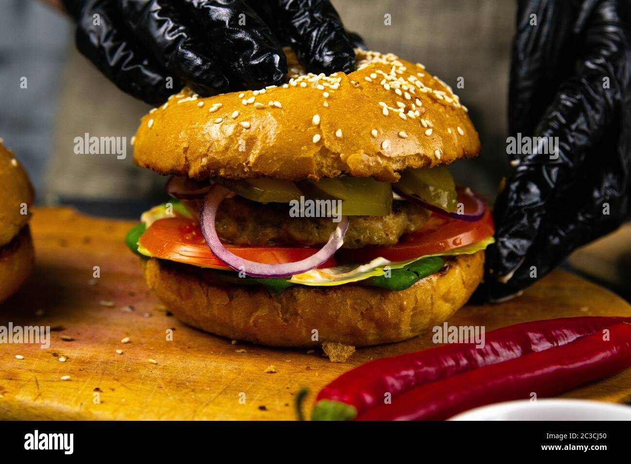 Process of cooking burgers. Cropeed view of chef hands in black gloves ...