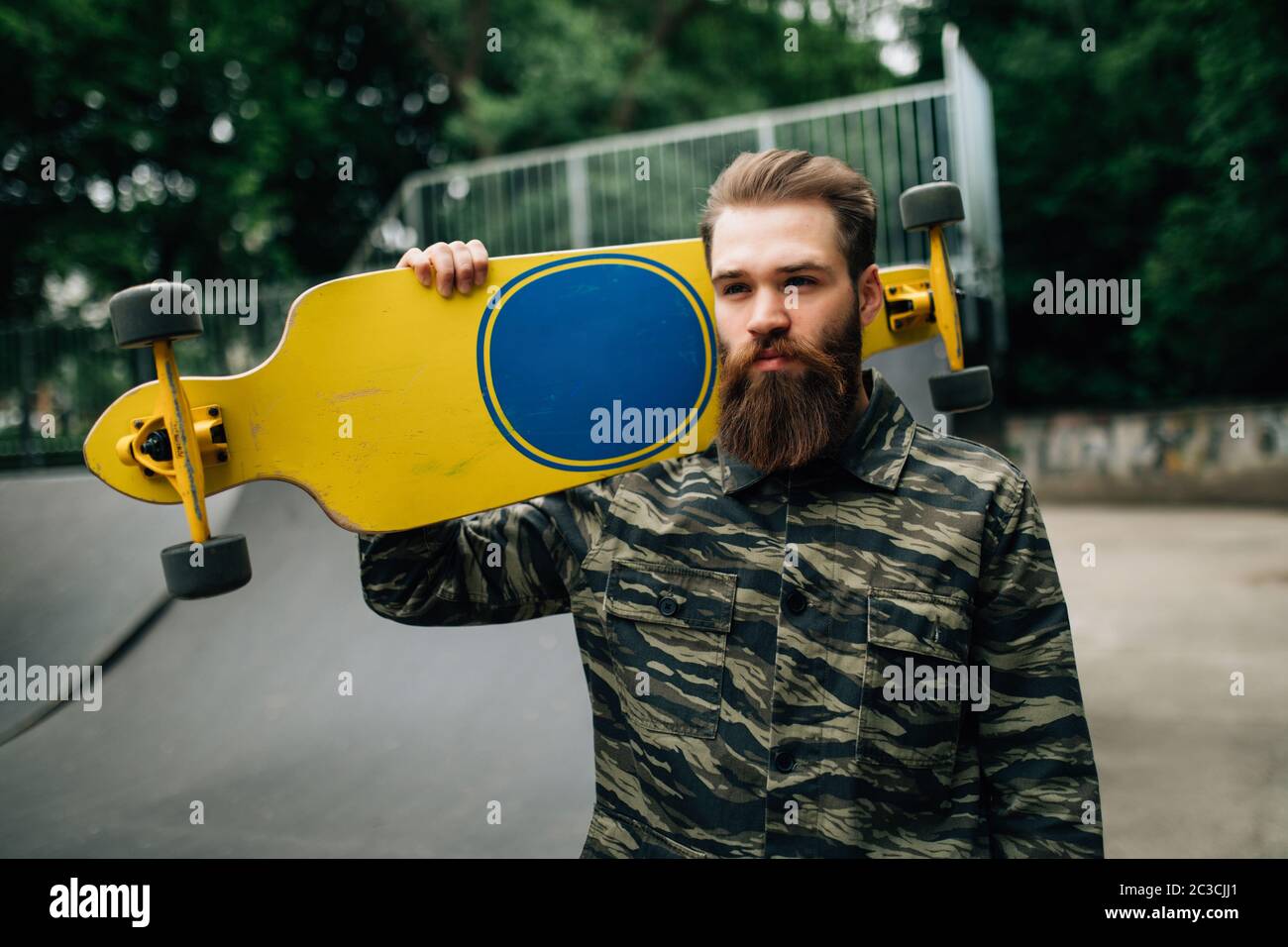 Urban guy lifestyle. Smiling bearded man with skateboard in extreme ...