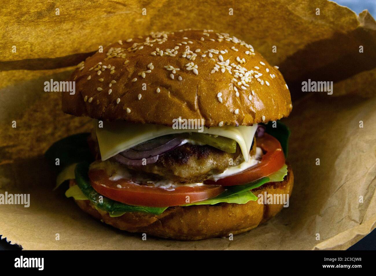 Hamburgers on white wrappers. Old wooden table with burgers. Juicy ...