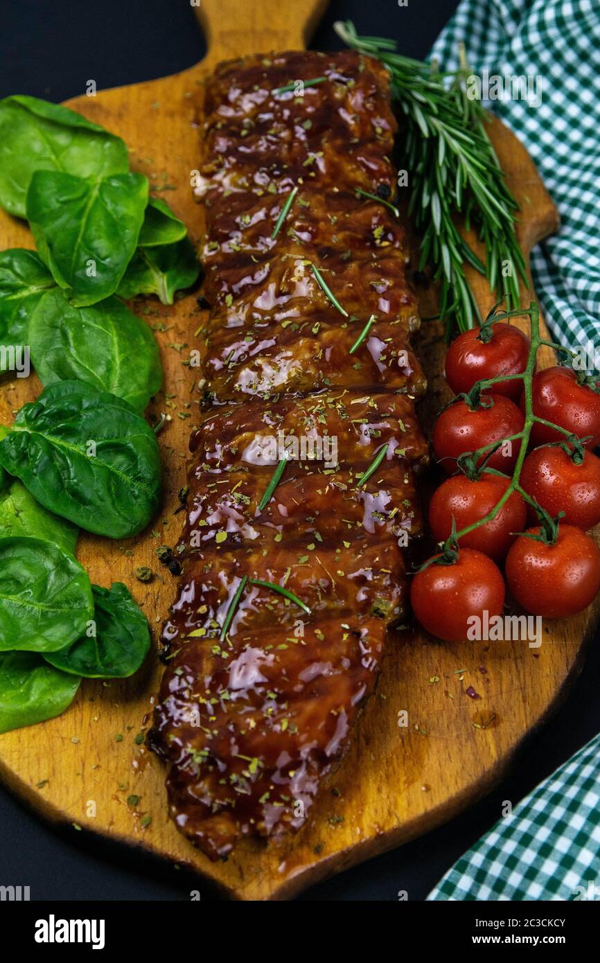 Barbecue Pork Spare Ribs as side view with basil and tomatoes and hot ...